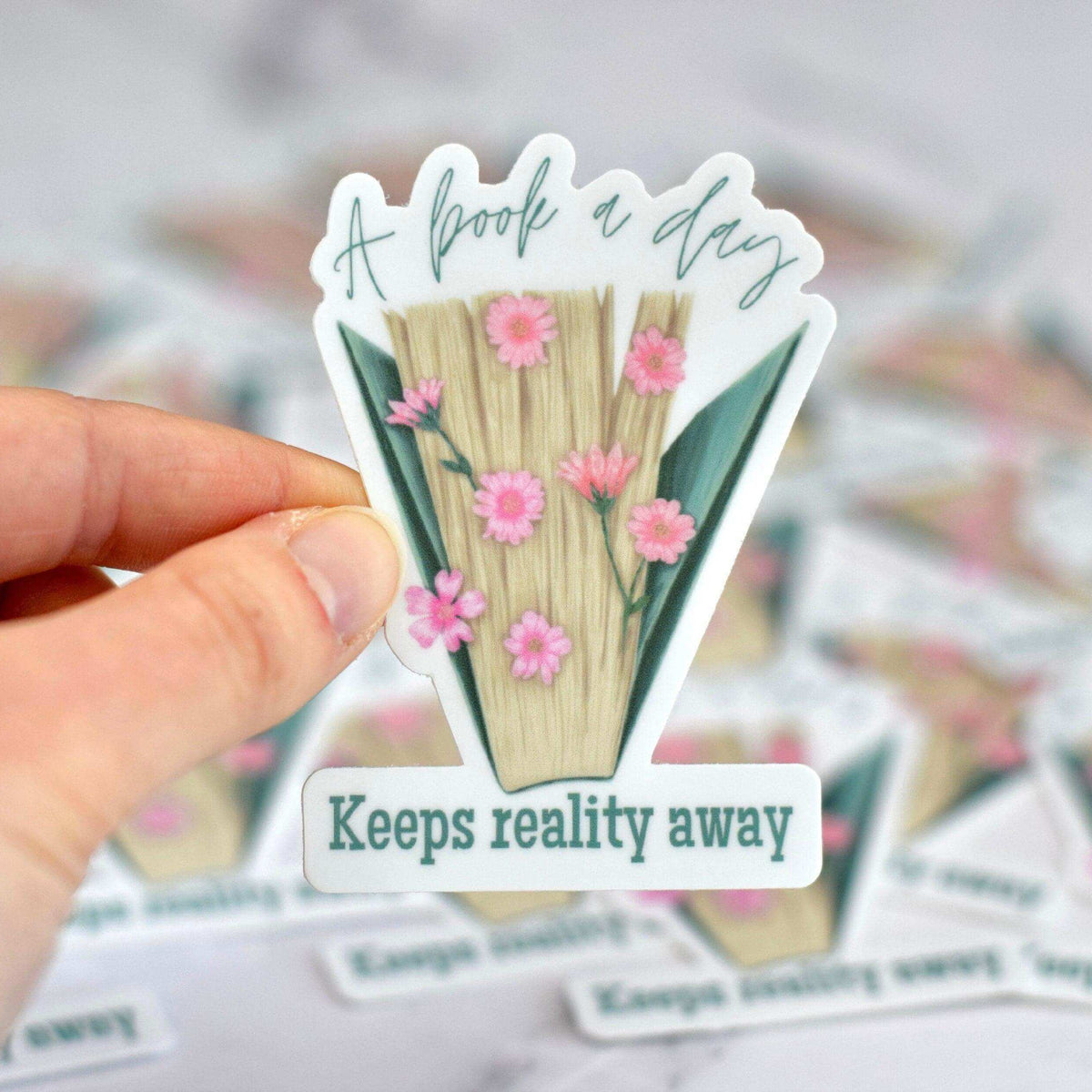 A Book a Day Keeps Reality Away Sticker | Winks Design Studio,LLC